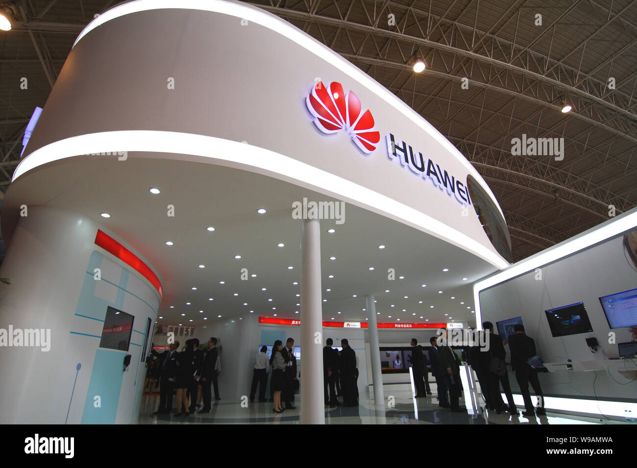 Chinese visitors are seen at the stand of Huawei Technologies during an ...