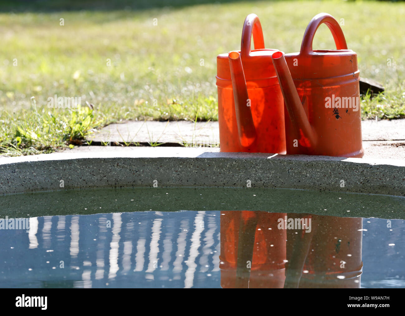Two blue watering cans hi-res stock photography and images - Alamy