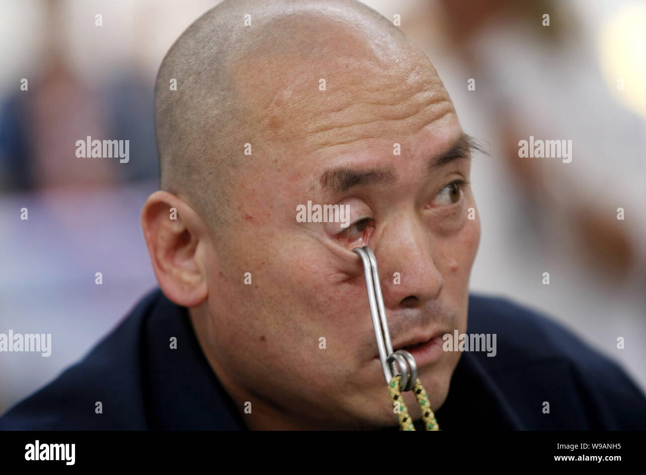 Chinese stuntman Dong Changsheng puts a hook on his eyelid during the ...