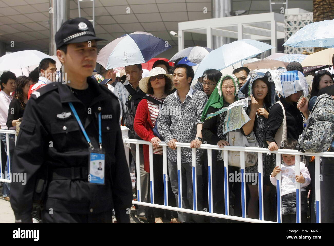 A security guard walks past crowds of visitors queuing up to enter the ...