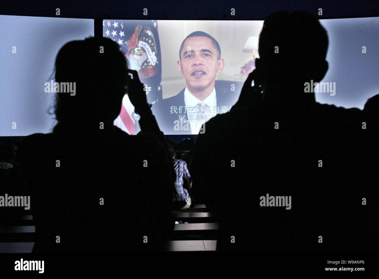 Visitors watch a welcome video by U.S. President Barack Obama inside ...
