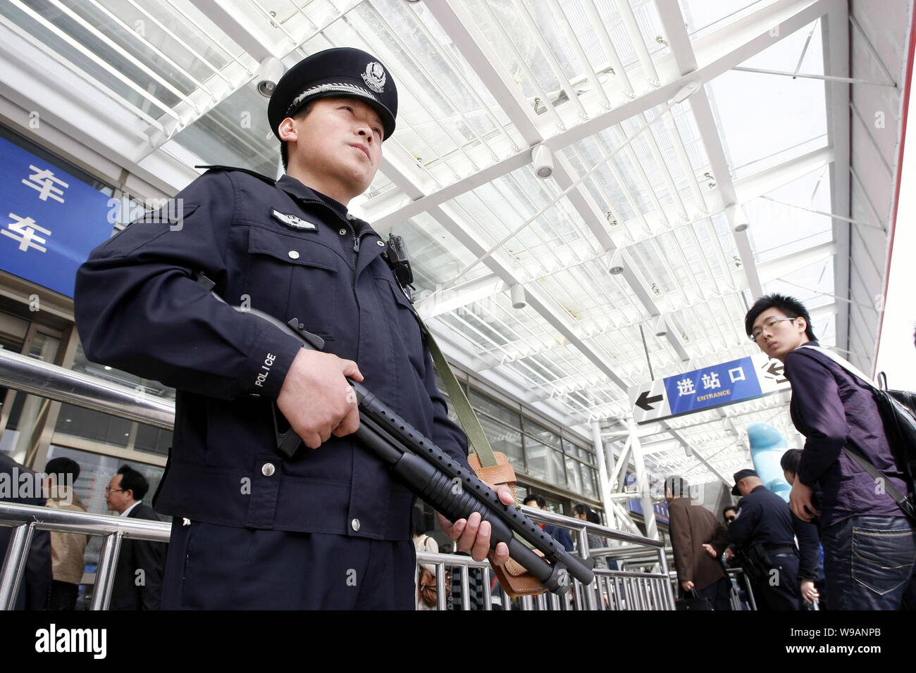 An armed Chinese policeman stands guard at the Shanghai Railway Station ...