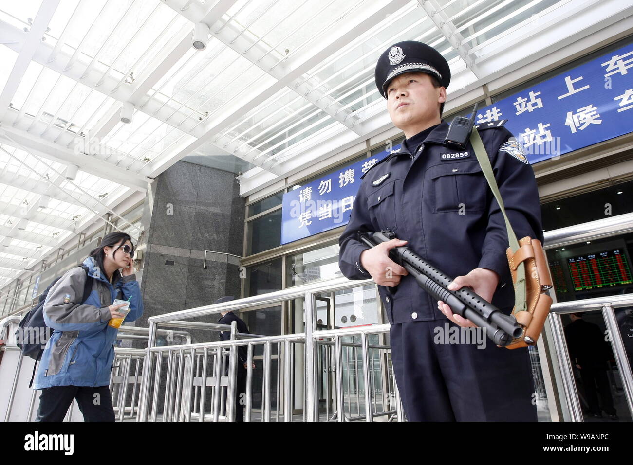 An armed Chinese policeman stands guard at the Shanghai Railway Station ...