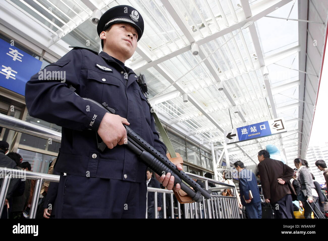 An armed Chinese policeman stands guard at the Shanghai Railway Station ...
