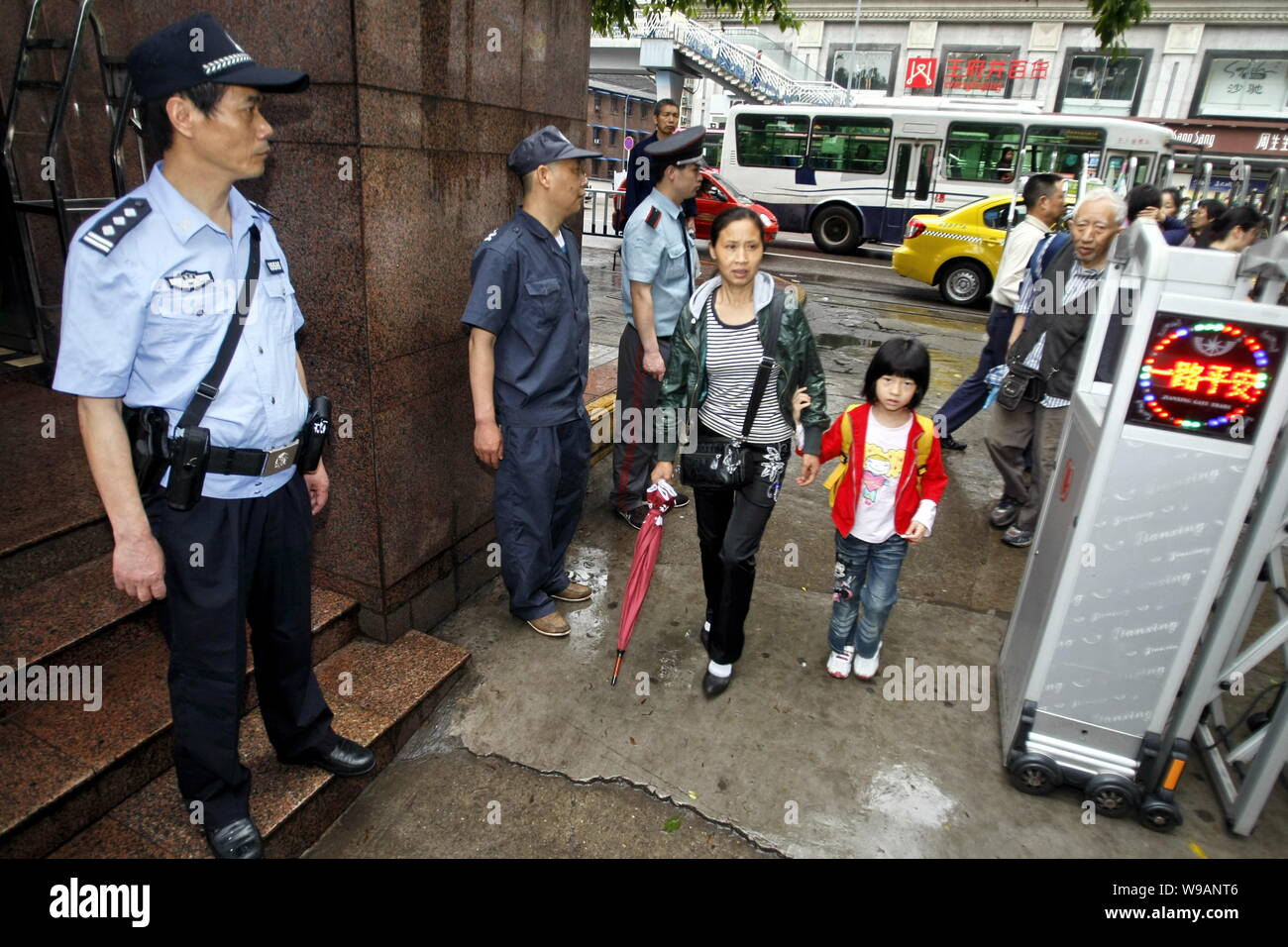 Police officer, security guard and school worker stand guard at the ...