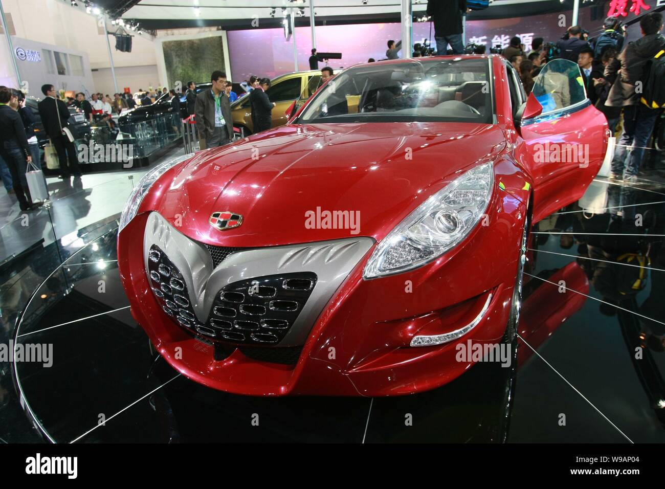 Visitors look at a Geely Emgrand GT during the 11th Beijing ...