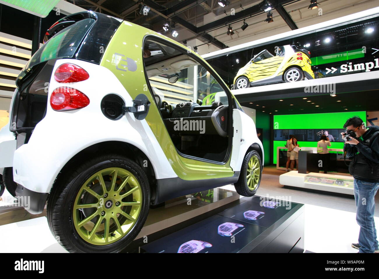 Visitors look at a SMART electric car of Mercedes-Benz at the 11th ...