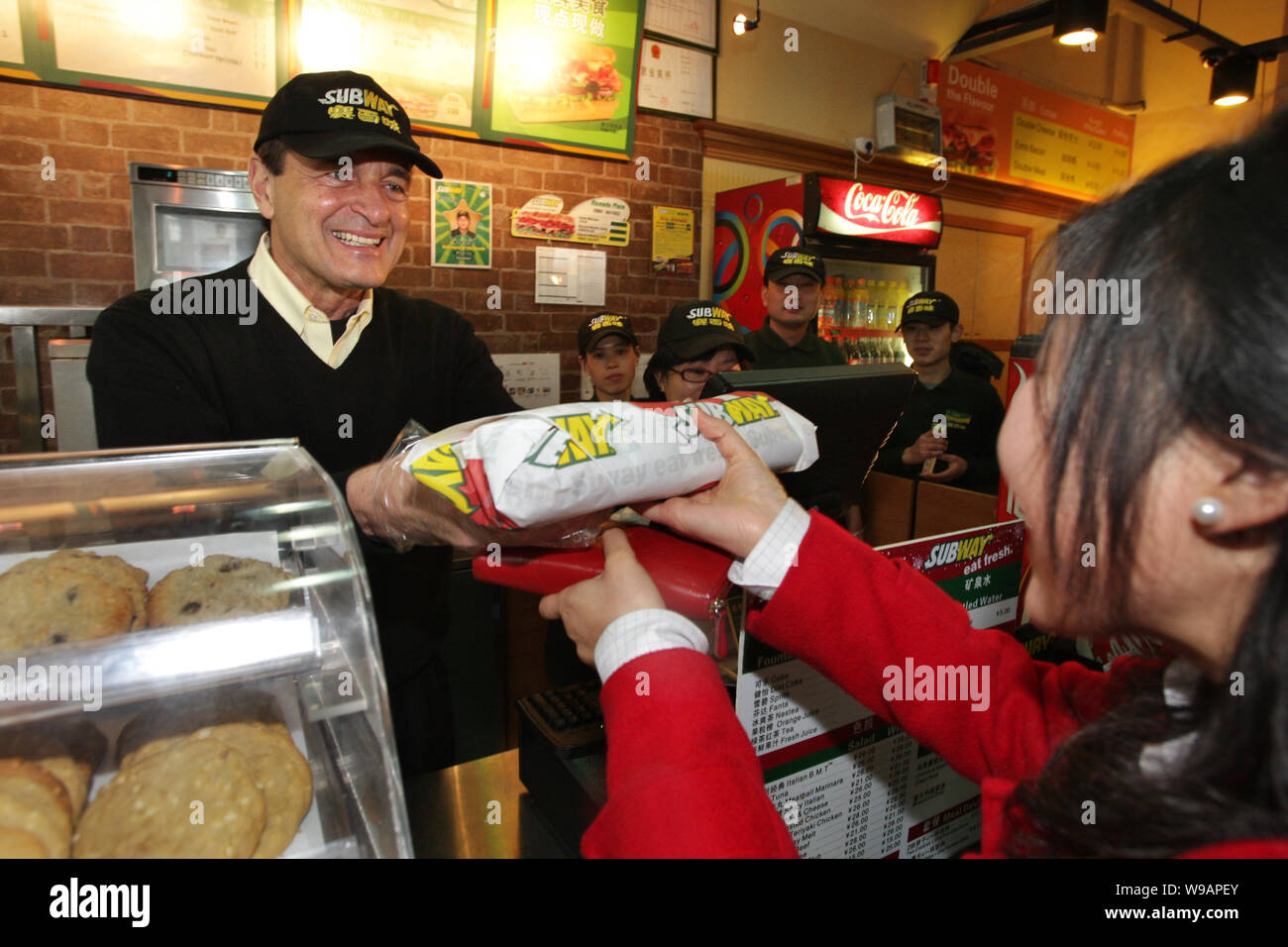 Fred DeLuca, President of Subway, serves a customer at a Subway ...