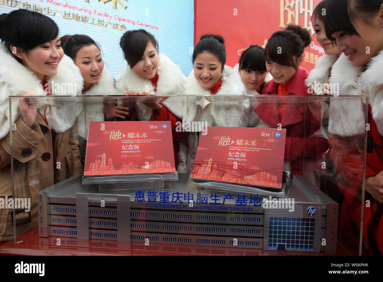 Chinese ritual girls look at two newly-manufactured HP laptop computers ...