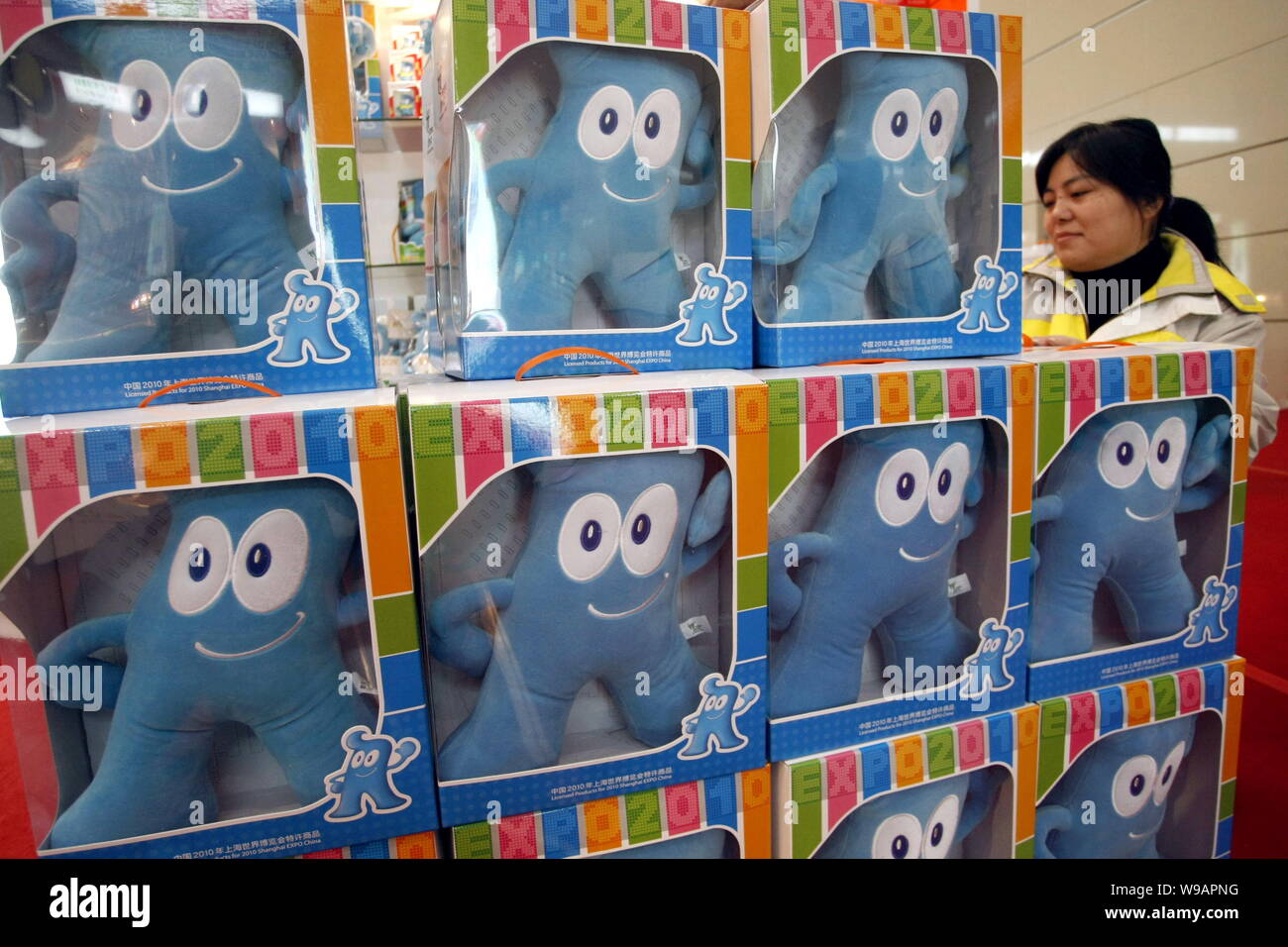 A Chinese employee arranges toys of Haibao, the official mascot of the ...