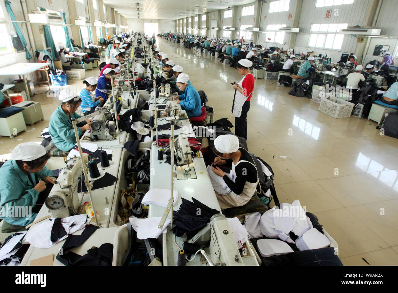 Female Chinese factory workers manufacture clothes to be exported to the U.S. and European ...