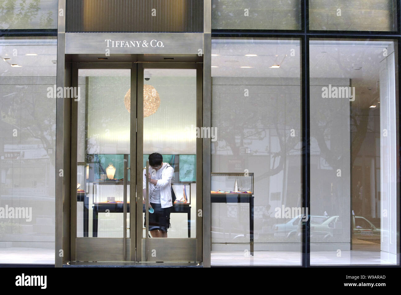 A local resident walks out of a Tiffany & Co store in Shanghai, China ...