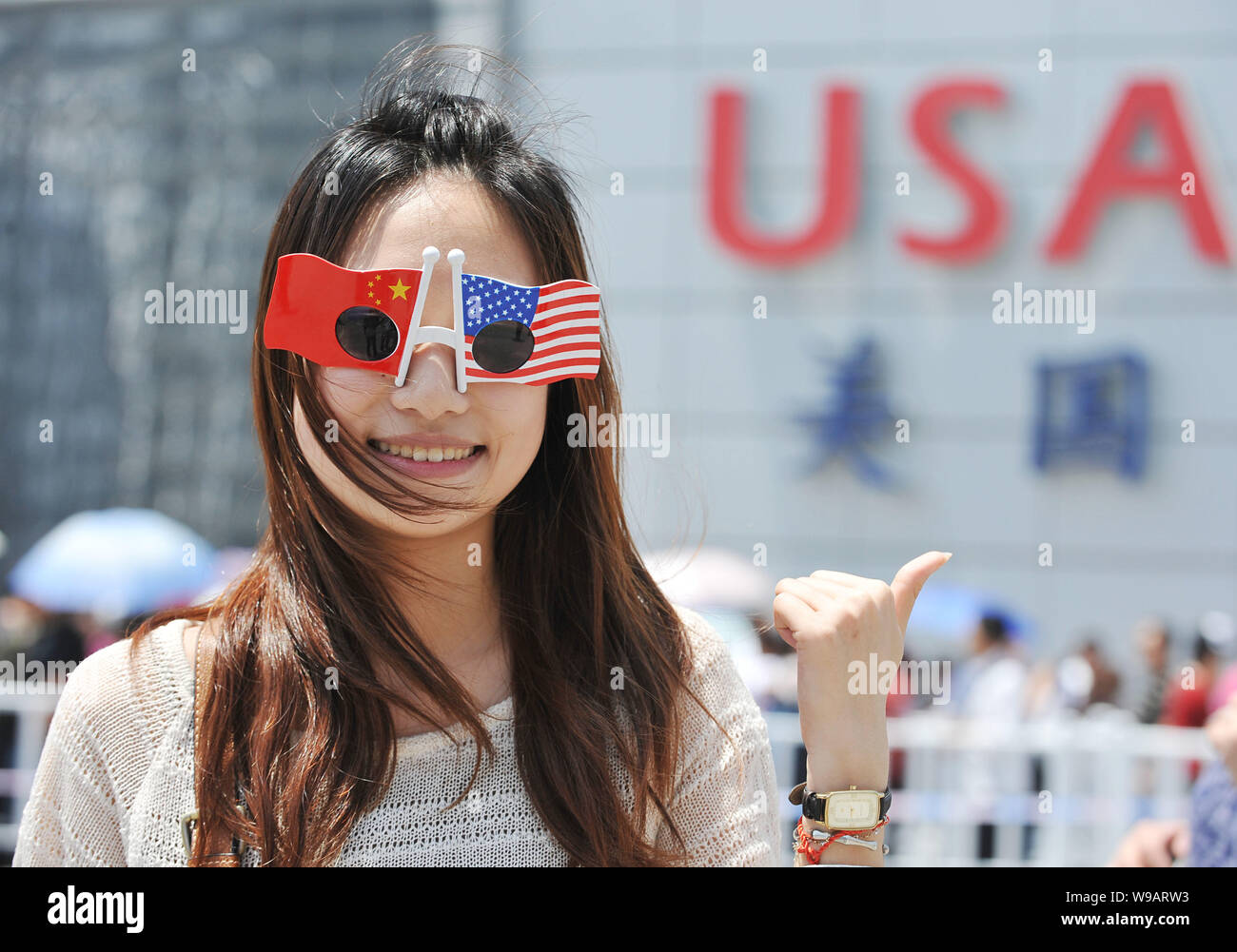 A visitor wearing a pair of glasses with images of Chinese and US ...