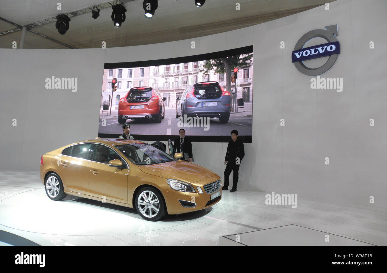 Visitors look at a Volvo car during an auto show in Beijing, China ...