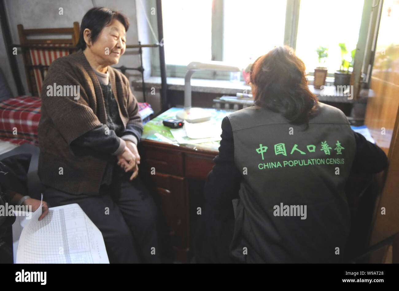 A Chinese census taker records personal information of a local resident ...