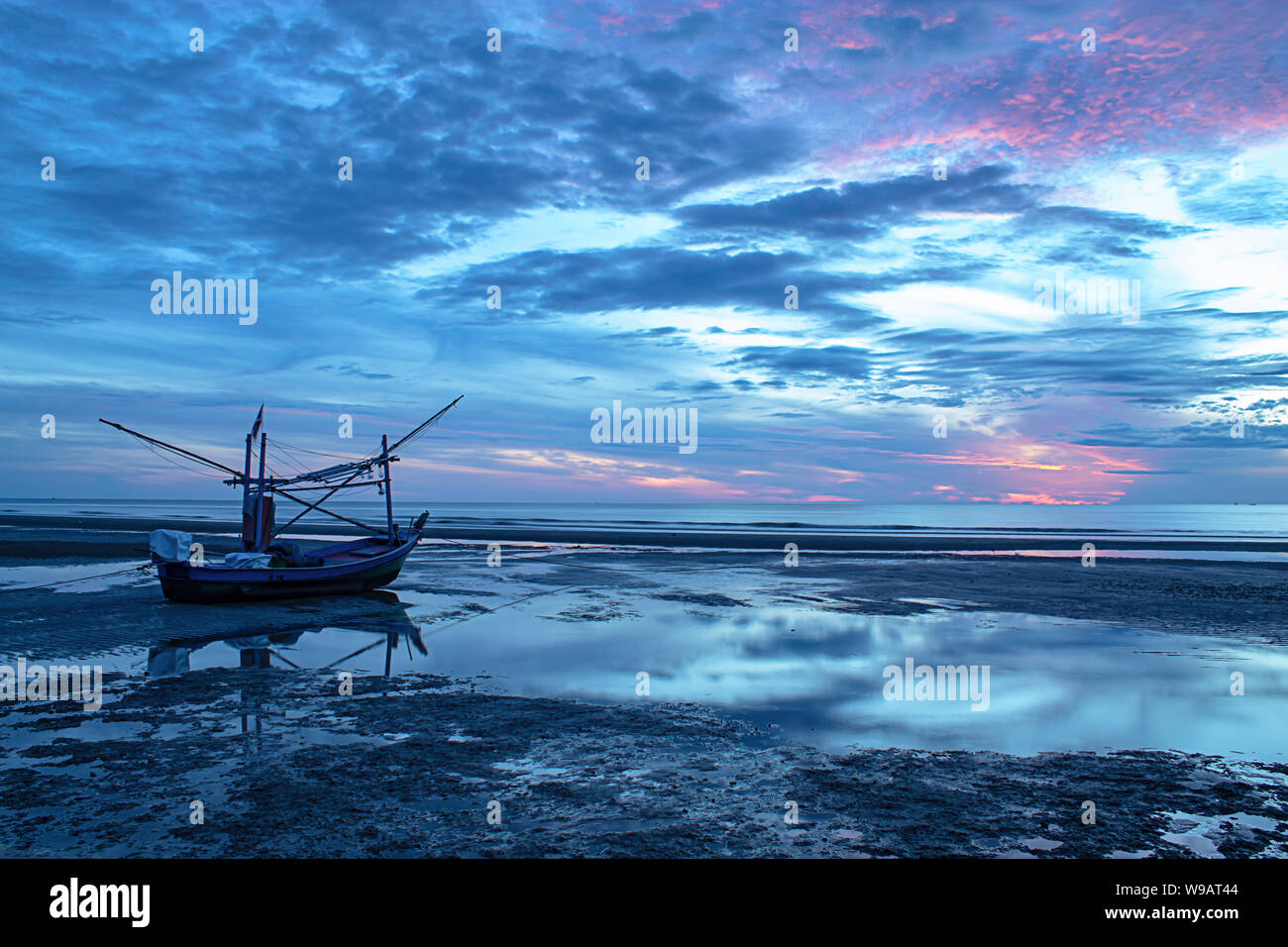 The morning sun light in the sea, and the boat on the beach Stock Photo ...