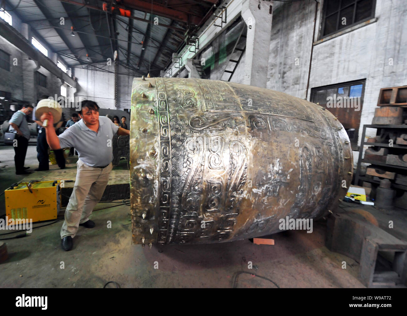 A Chinese expert beats a bronze drum in a casting and forging plant in ...
