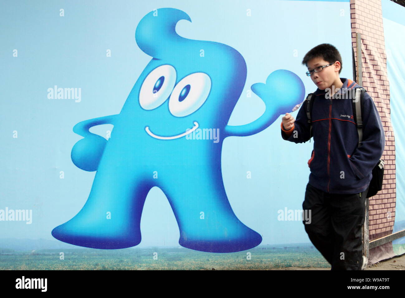 A Chinese student walks past an advertising poster for the World Expo ...