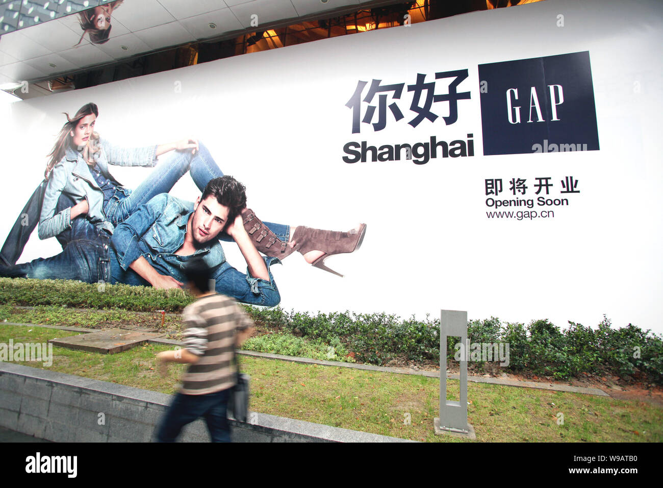 A Chinese man walks past an advertisement of Gap in Shanghai, China ...