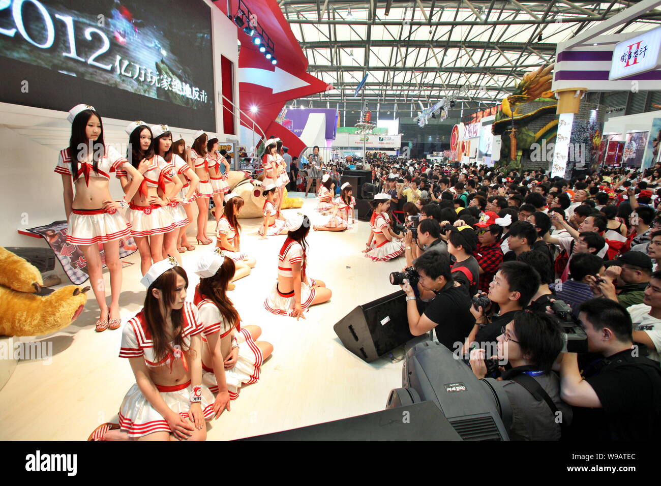 A crowd of visitors look at models wearing COSPLAY outfits during the ...