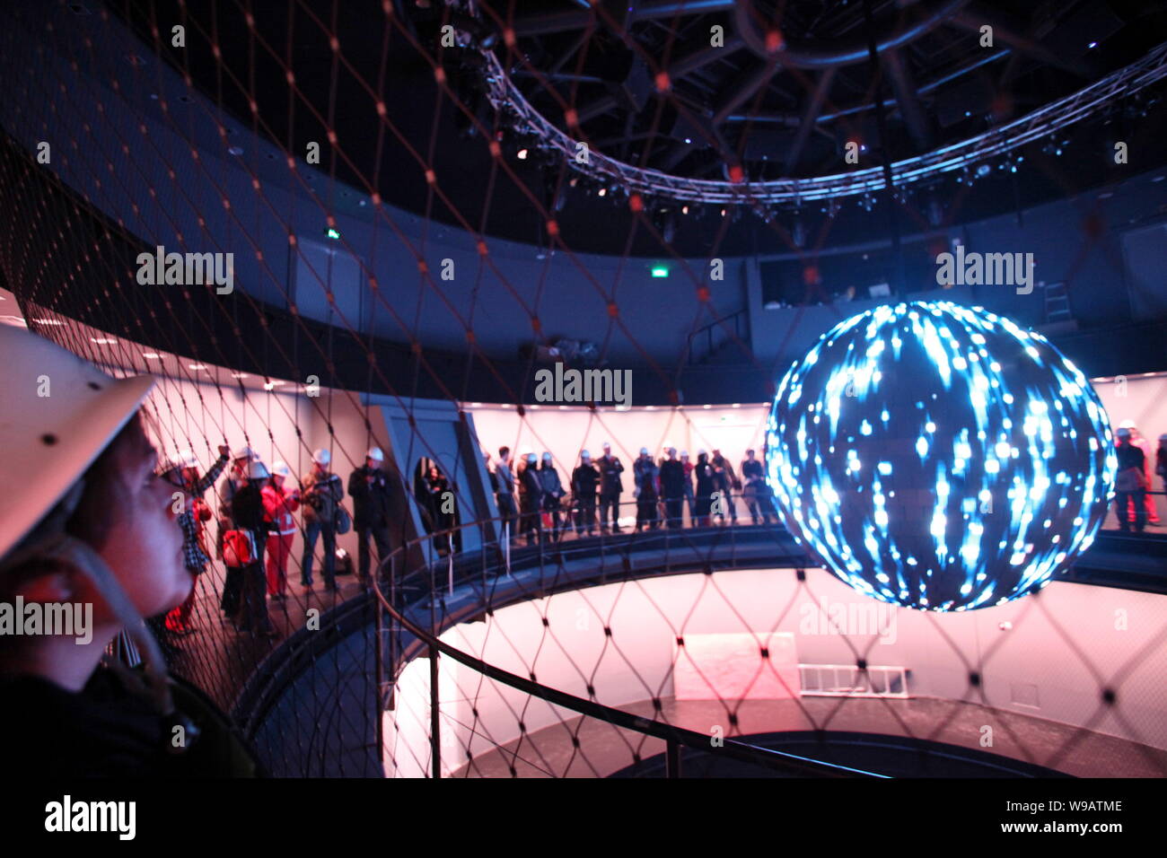Visitors watch a big sphere display in the German Pavilion in the Expo ...