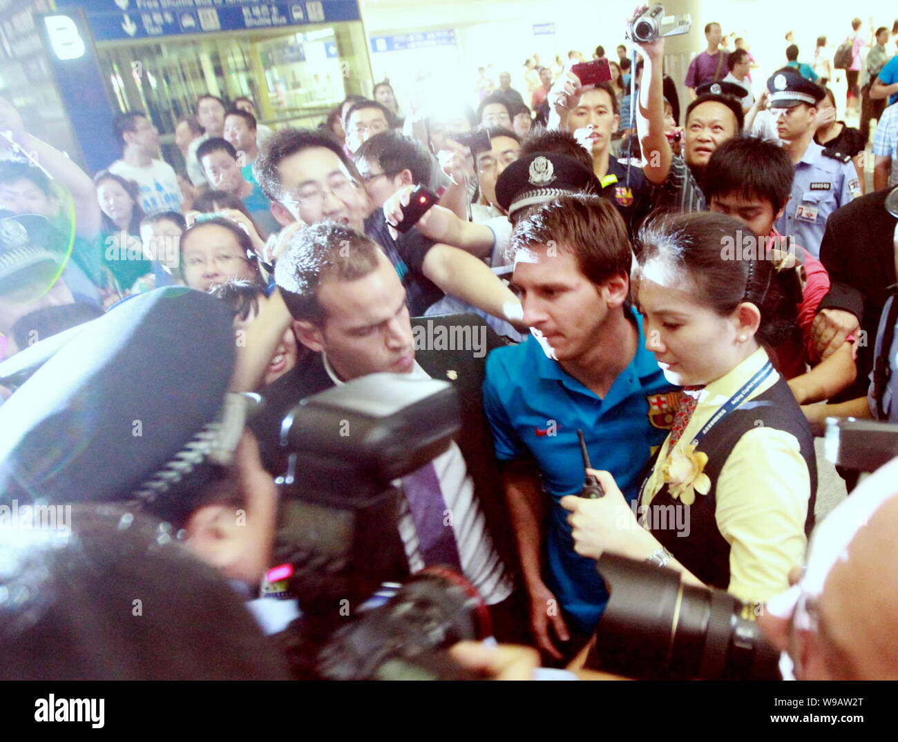 Argentine soccer player Lionel Messi of FC Barcelona is escorted to go ...