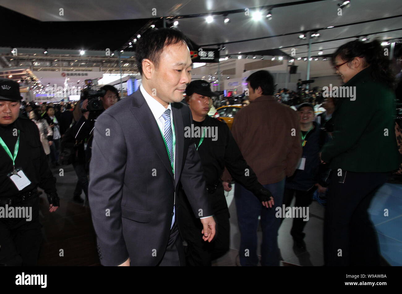 Li Shufu (C), Chairman and CEO of Geely Holding Group, visits the stand ...