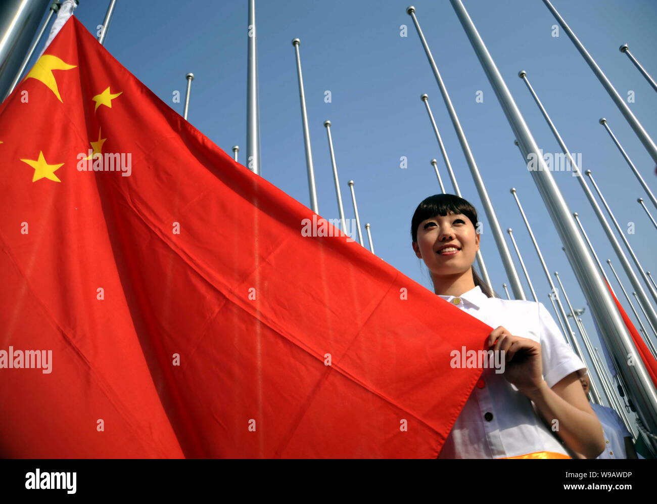 A Chinese hostess raises a Chinese national flag during the flag ...