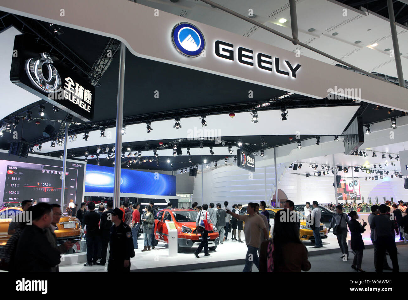 Visitors walk past the stand of Geely during an auto show in Guangzhou ...