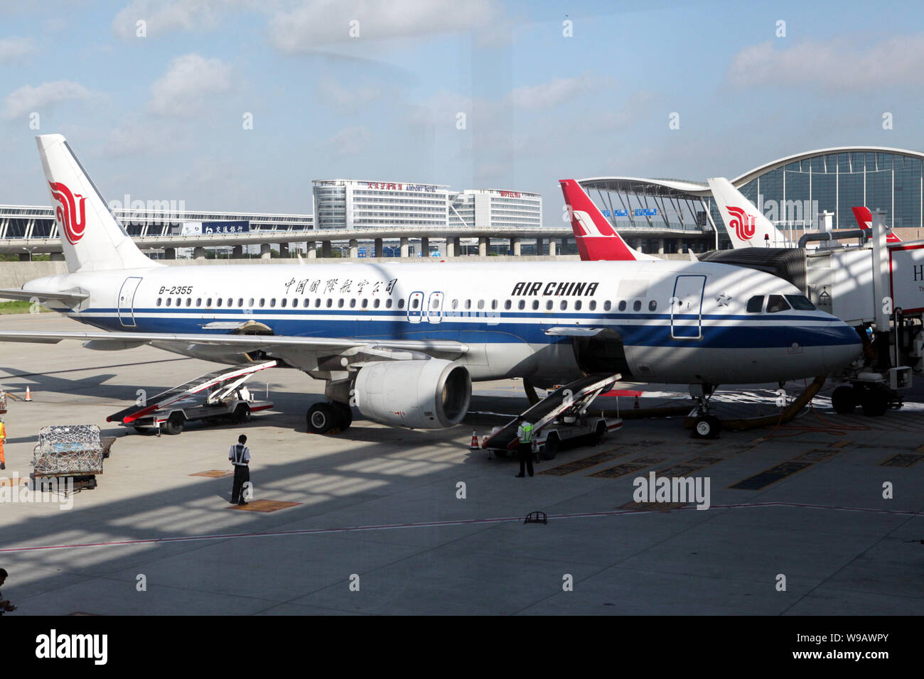--FILE--Chinese ground staff stand next to an Airbus A320-200 jet plane ...