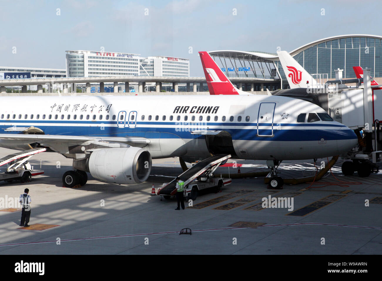 --FILE--Chinese ground staff stand next to an Airbus A320-200 jet plane ...