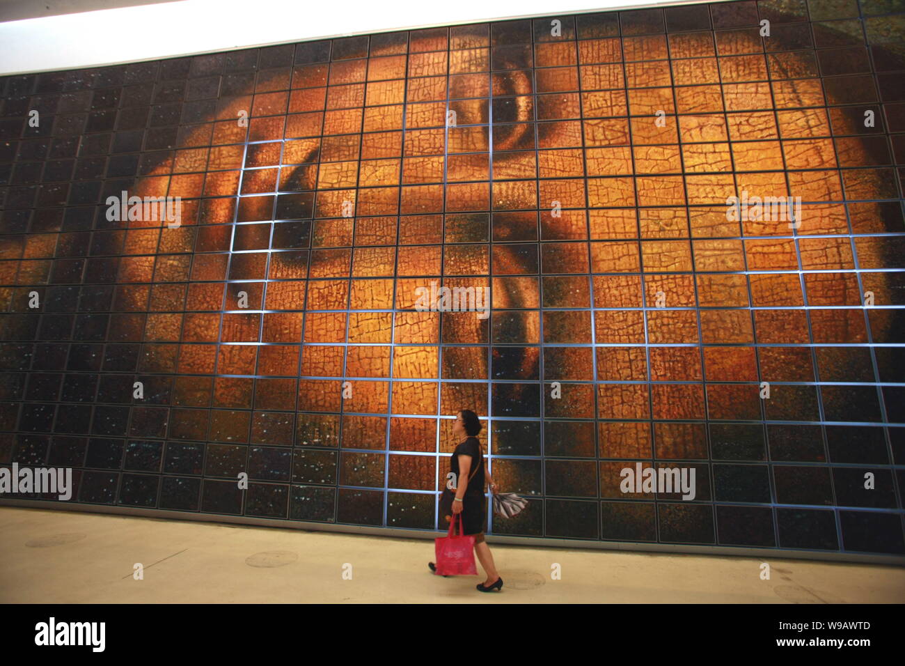 A Chinese woman walks past a huge portrait of Mona Lisa which is made ...