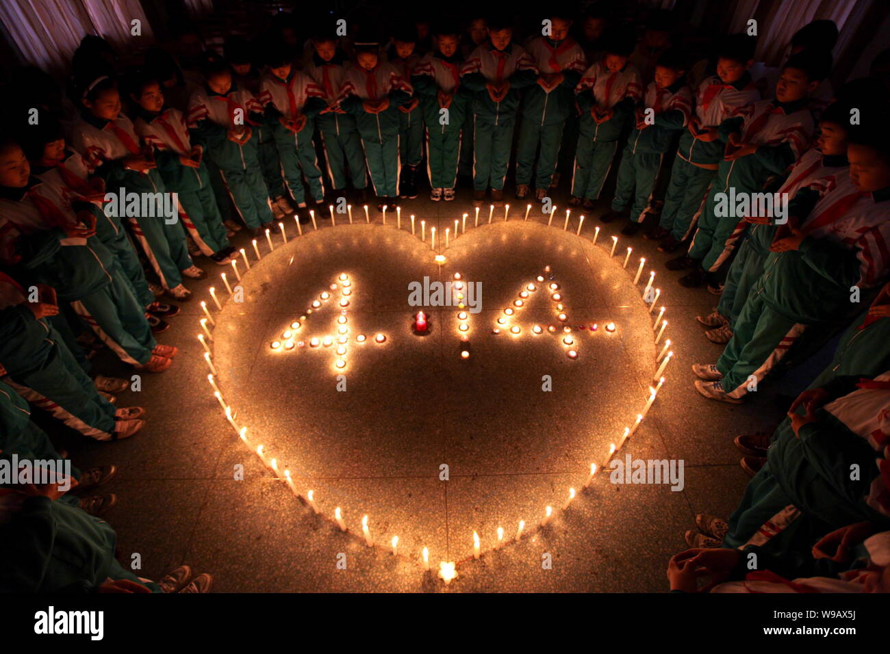 Chinese pupils standing around candles mourn for the victims of the ...