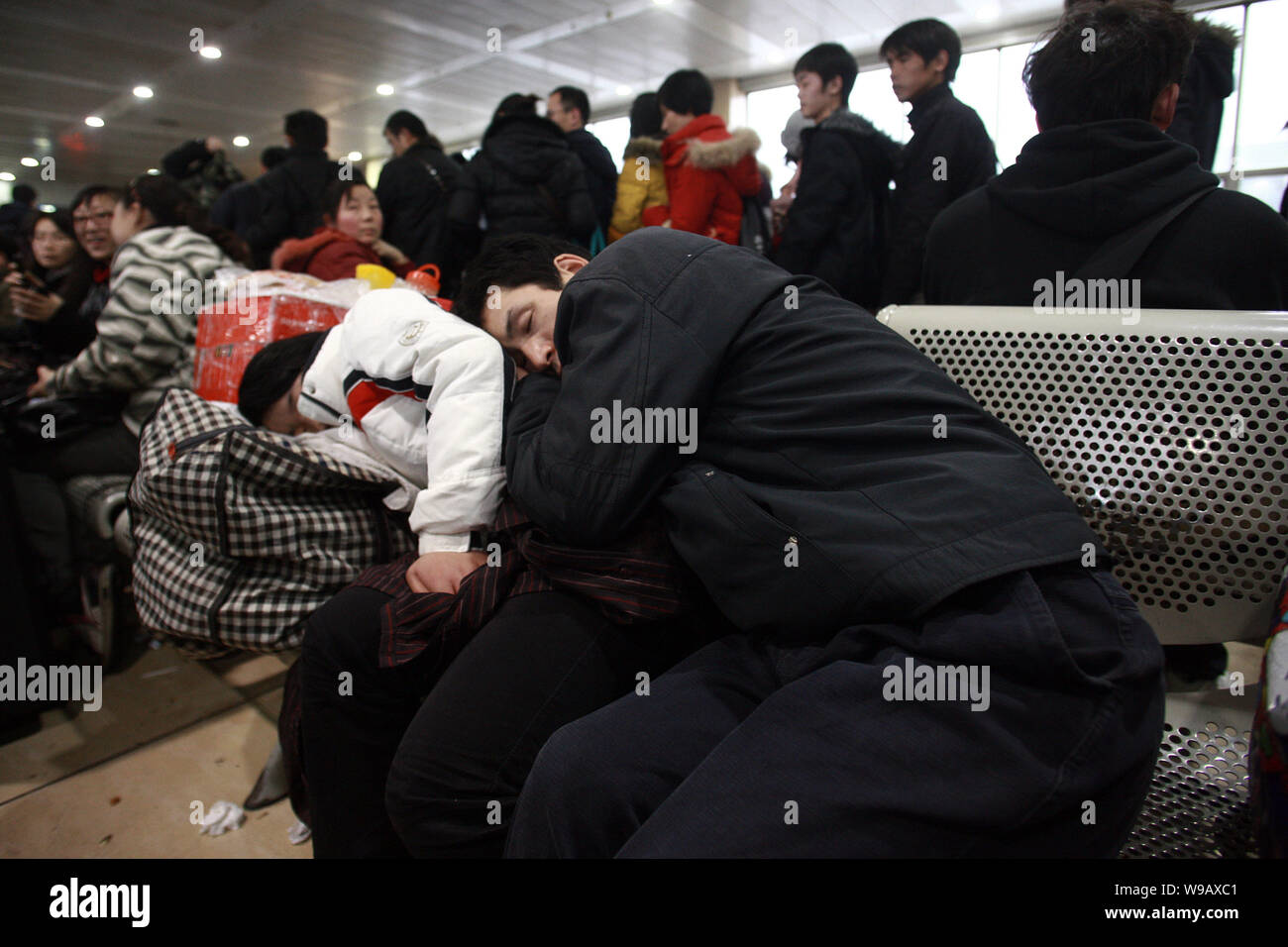 Two Chinese passengers take a nap while waiting at the Shanghai Railway ...