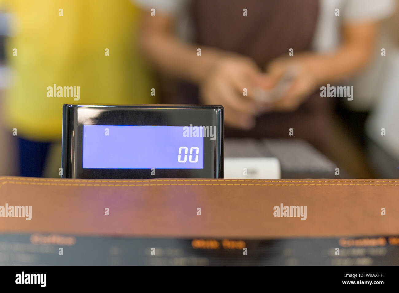 Selected focus cashier register with female waitress operating in cafe ...