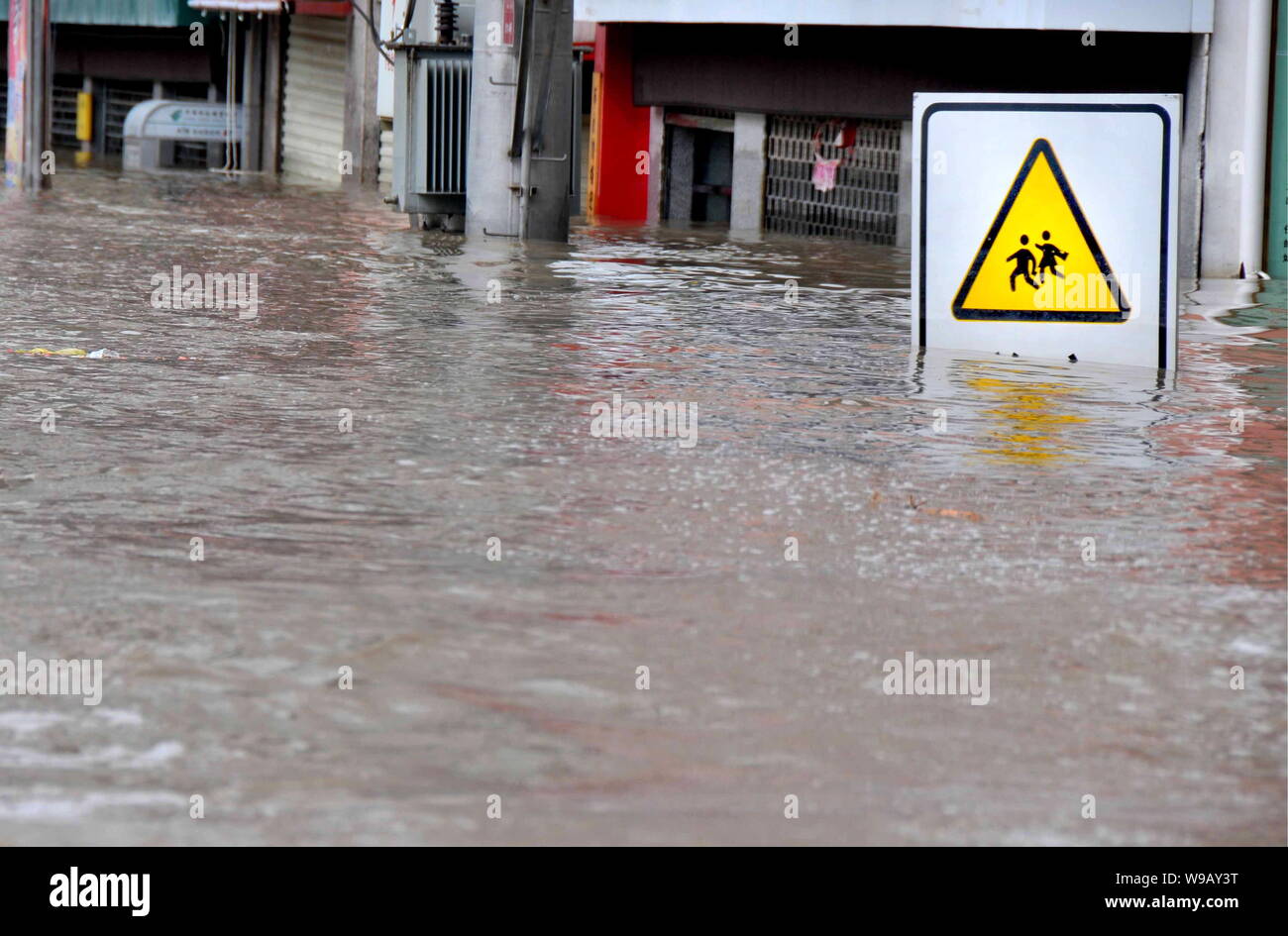 A road sign is submerged by floodwaters in the aftermath of the ...