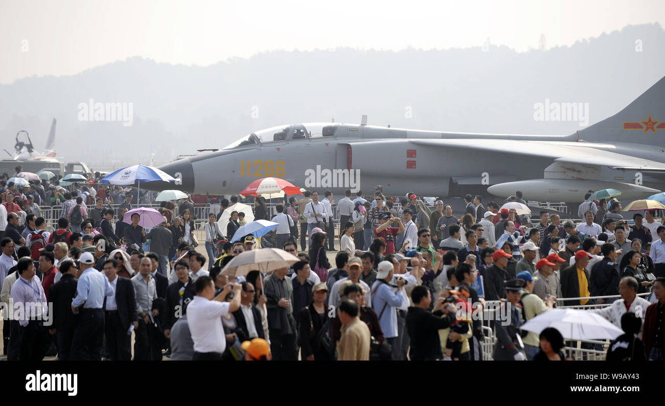 Visitors look at the FC-1 lightweight multipurpose fighter jet and ...