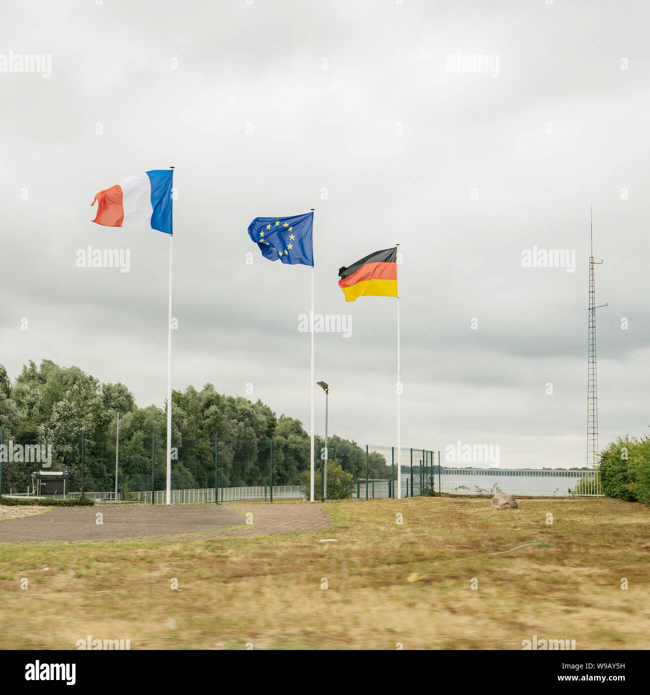 French, European union and German flags waving near the border between ...