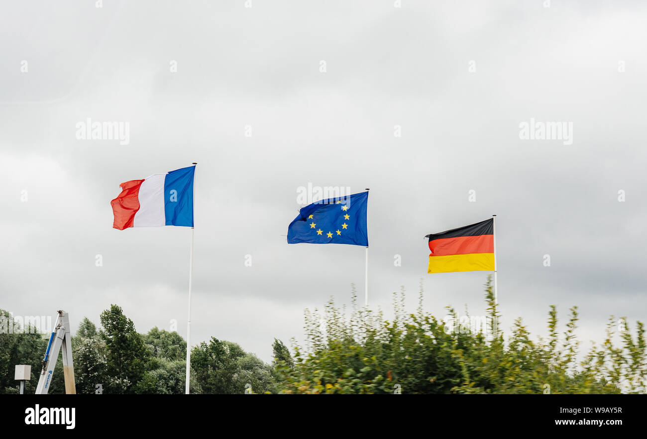 French, European union and German flags waving near the border between ...