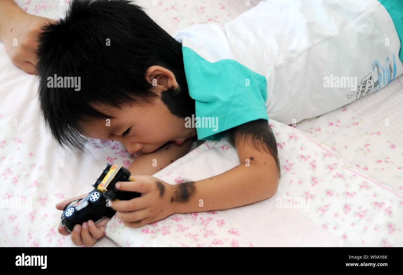 2-year-old hairy boy Bing Bing plays with toy cars at the Guangxi ...