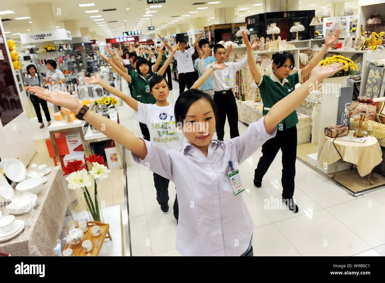 Chinese employees do a synchronized physical exercise at a shopping ...
