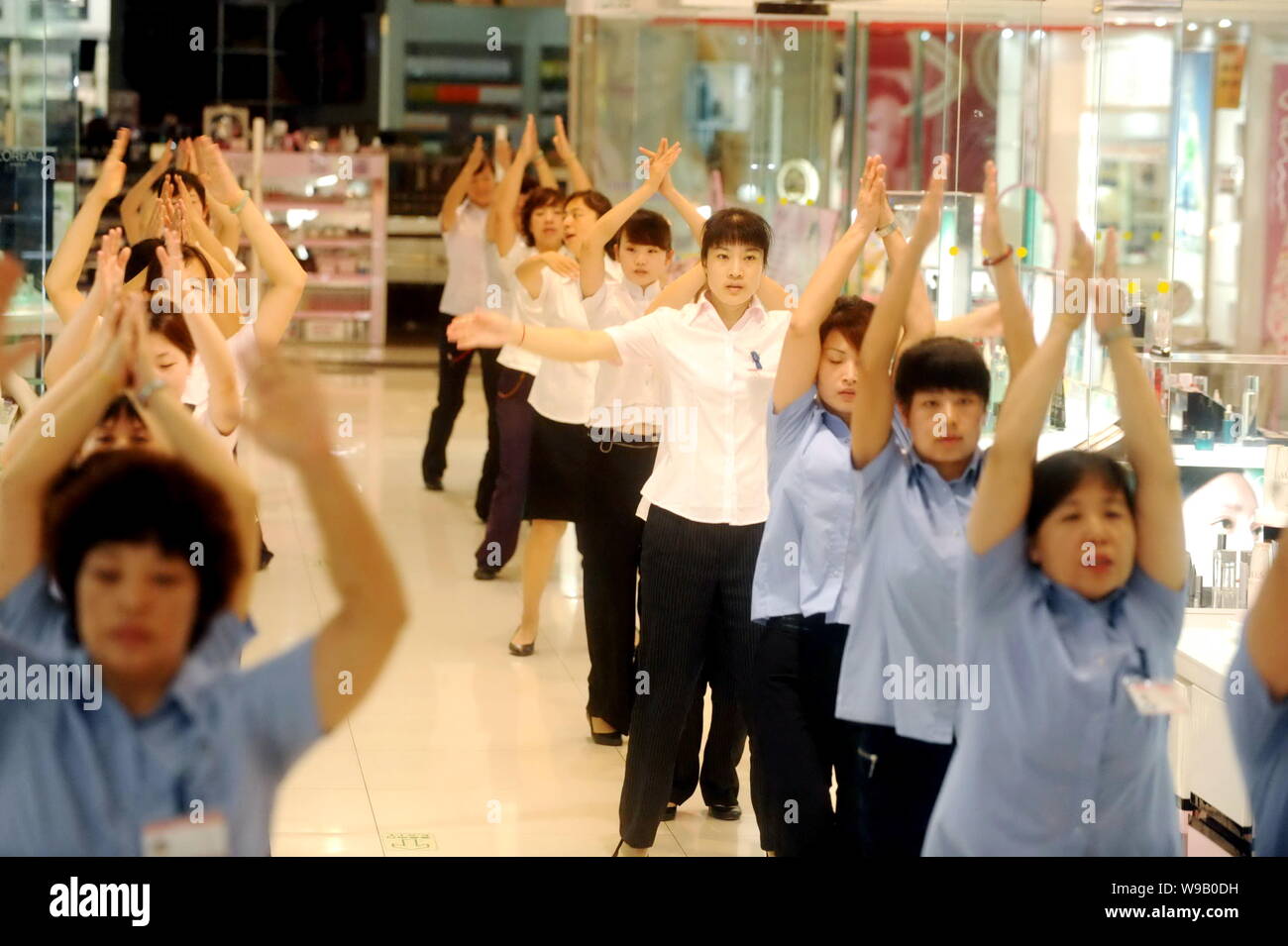Chinese employees do a synchronized physical exercise at a shopping ...