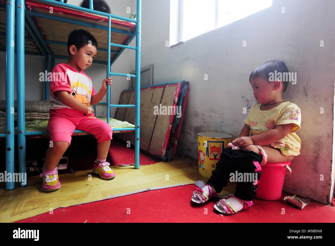 Chinese kids queue up to pee on a plastic bucket at the Shuangteng ...