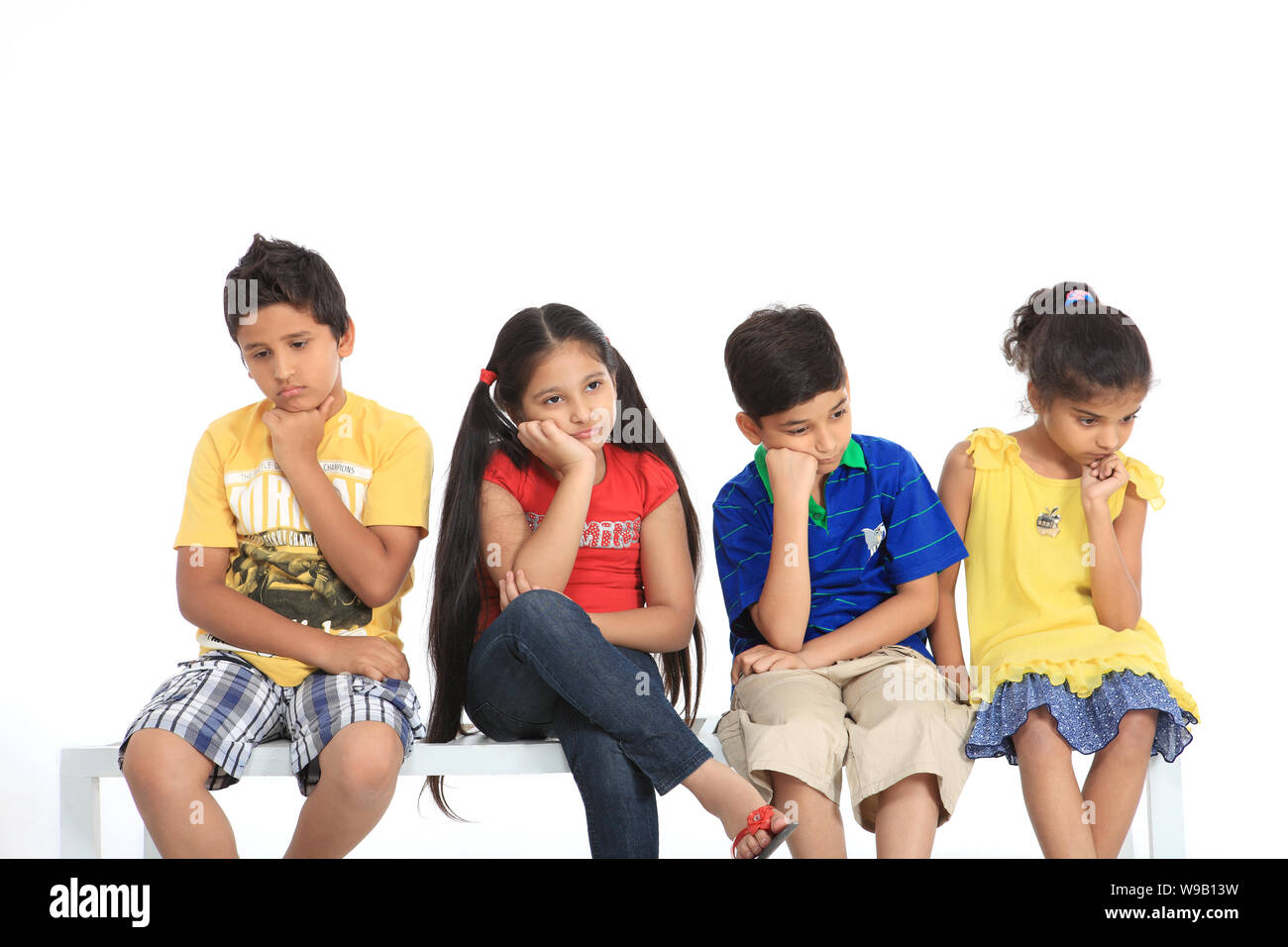Group of children sitting together and looking sad Stock Photo - Alamy