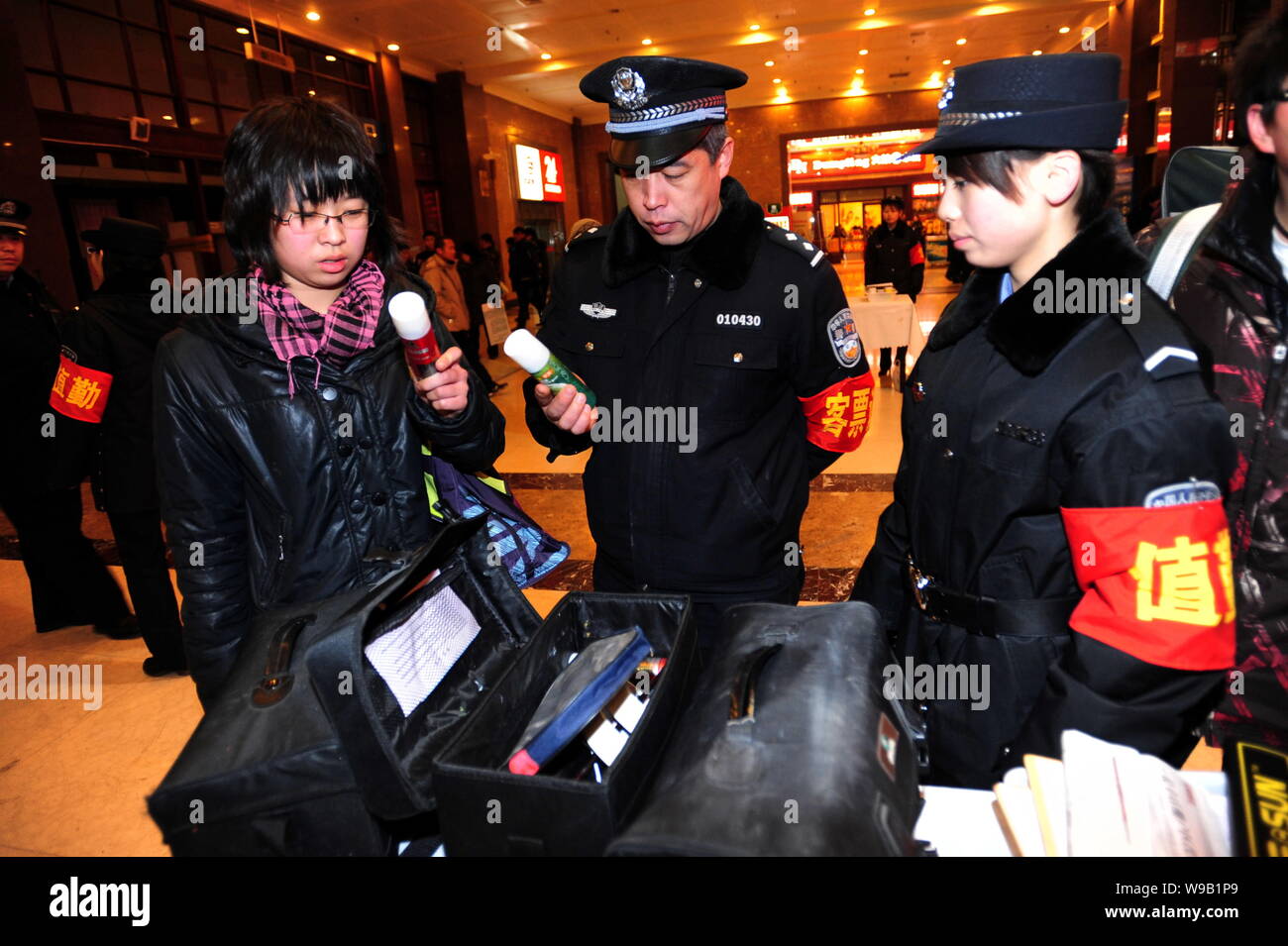 Chinese police officers check the luggage of a passenger at the Beijing Railway Station during ...