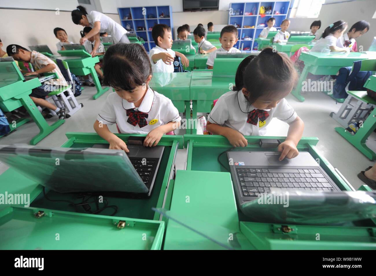 Primary school pupils using computers hi-res stock photography and ...