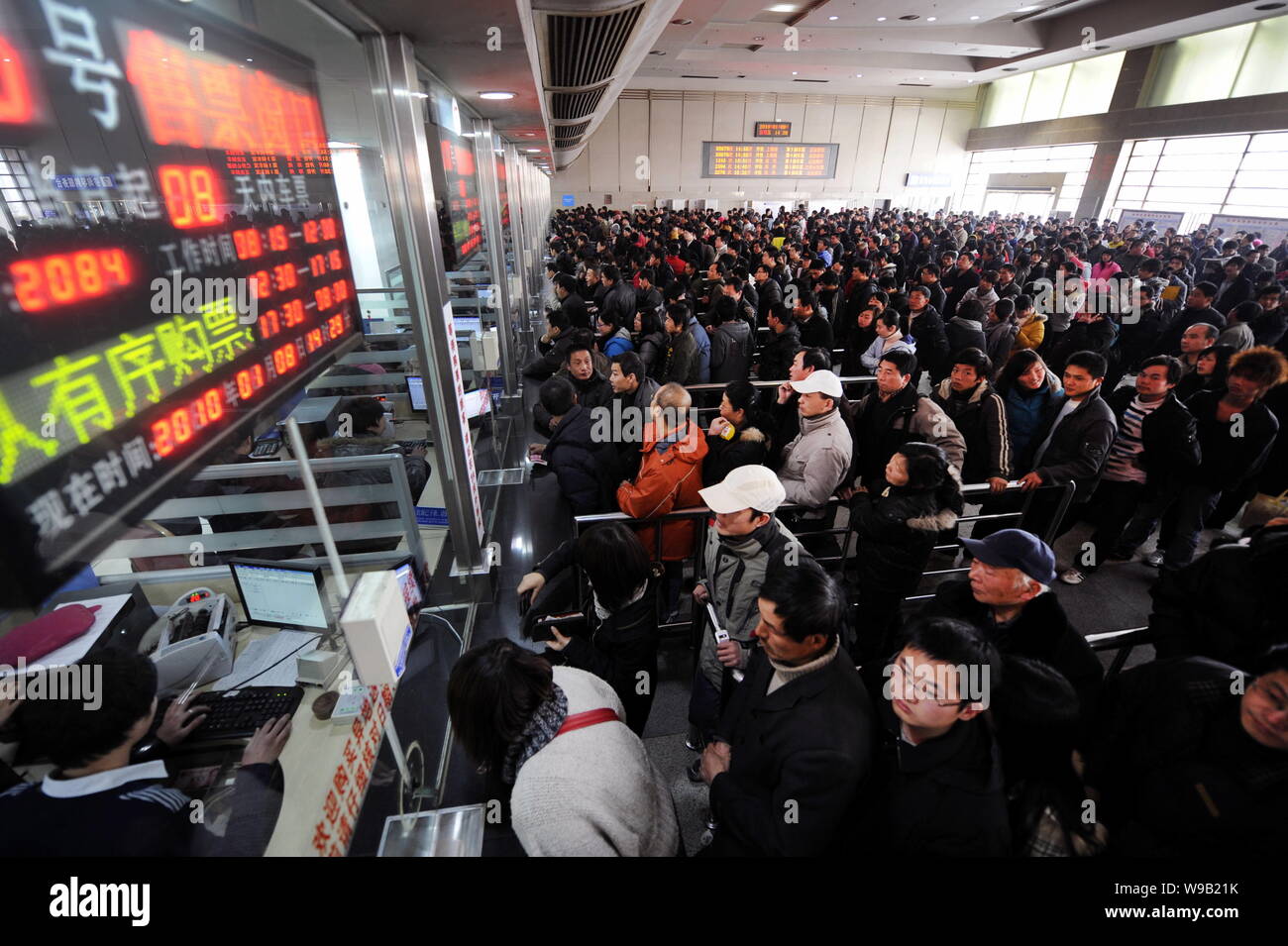Passengers queue up to buy train tickets at the Hangzhou Railway ...