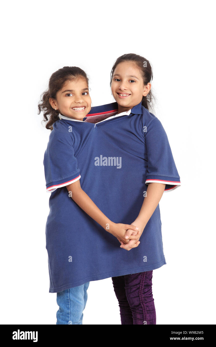 Two young girls wearing the same polo shirt Stock Photo - Alamy