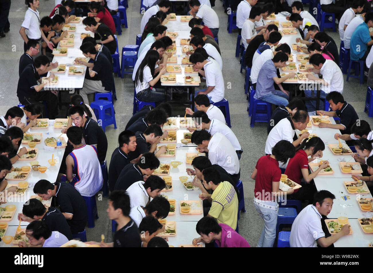 Chinese Foxconn employees have lunch in a dining hall at the Shenzhen ...