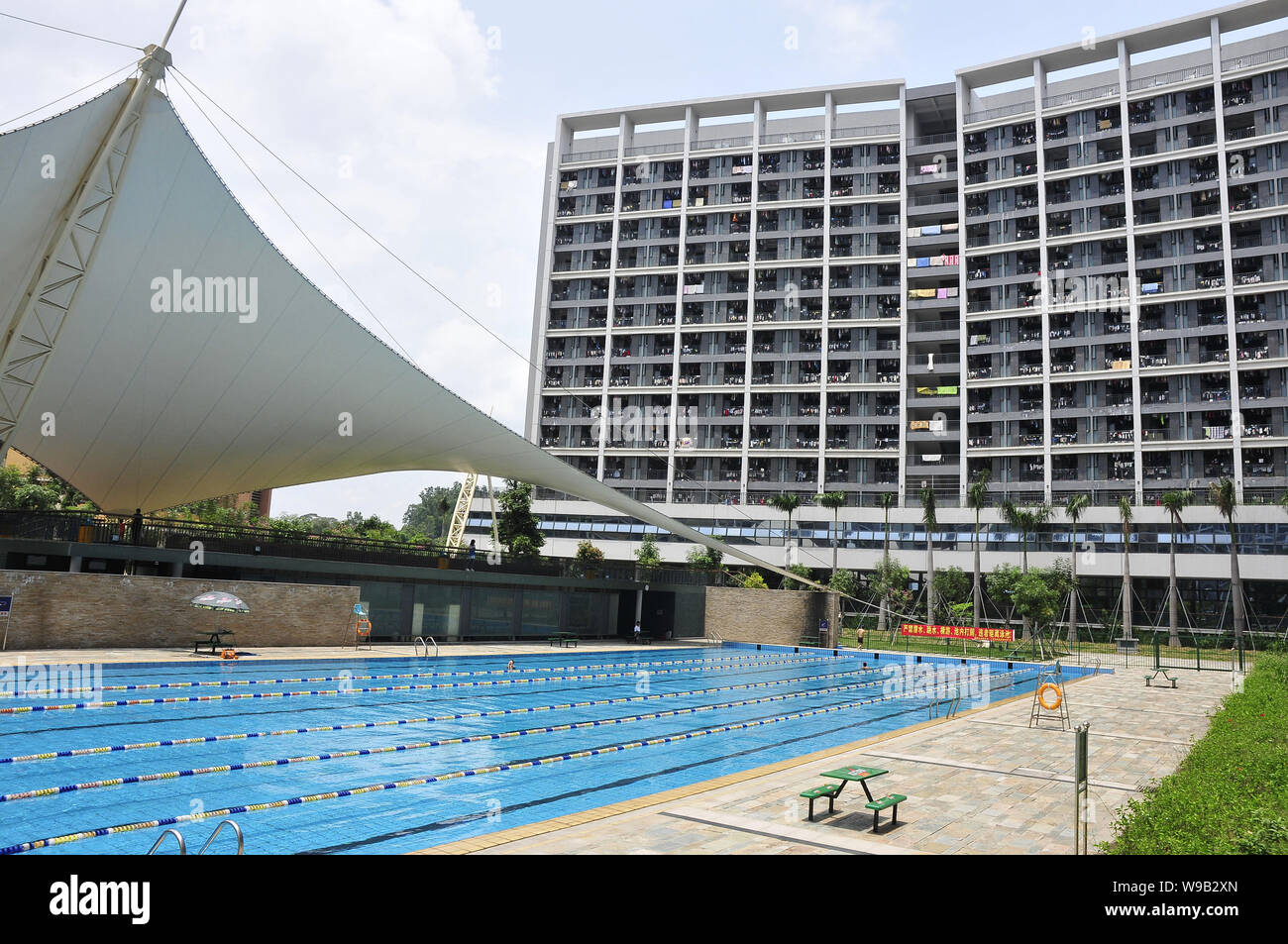 View of a swimming pool in front of a dormitory building at the ...